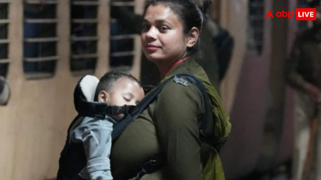 Reena female constable doing duty with a 1 year old child tied on her chest at New Delhi Railway ...